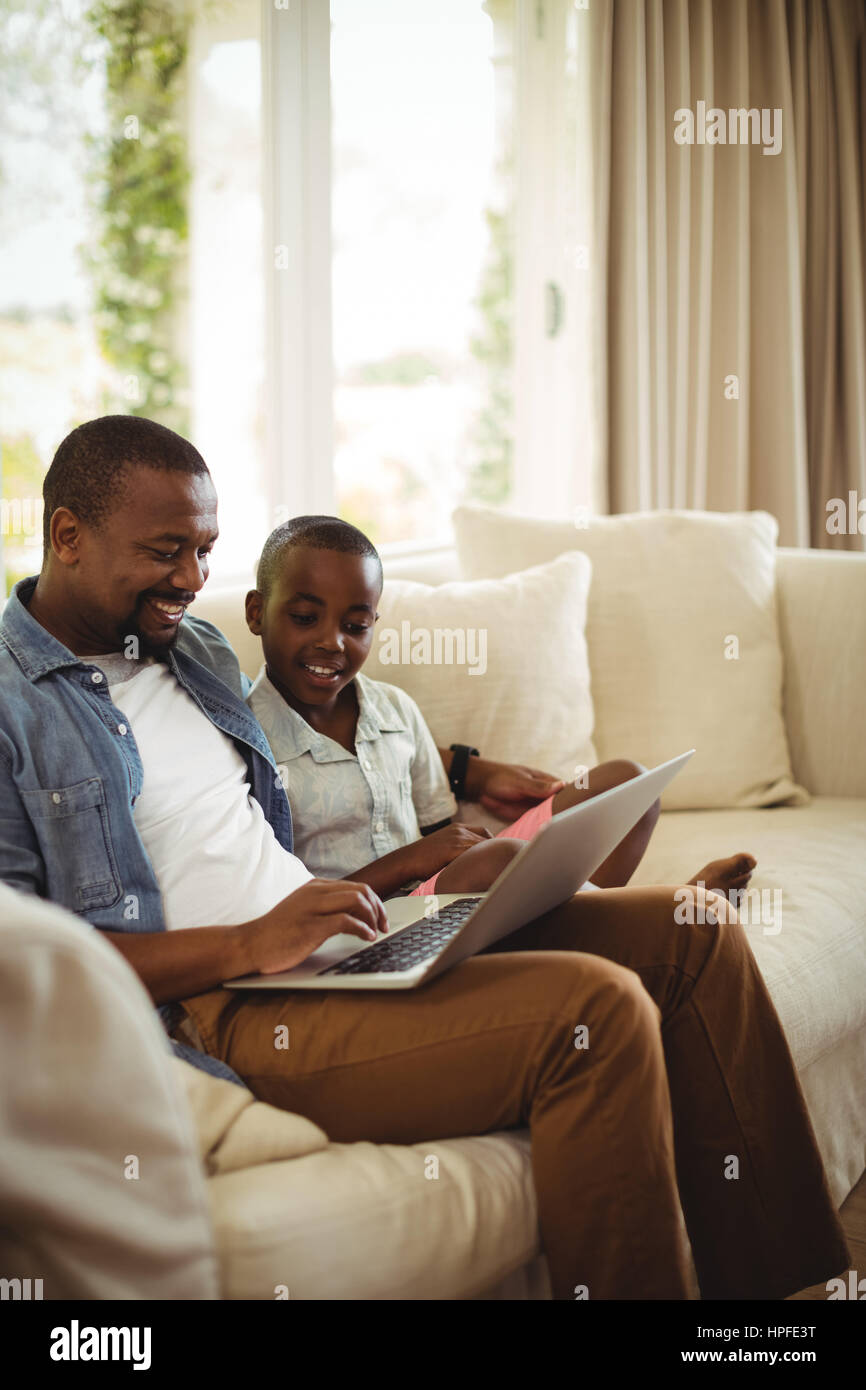 Father and son using laptop in living room at home Stock Photo - Alamy