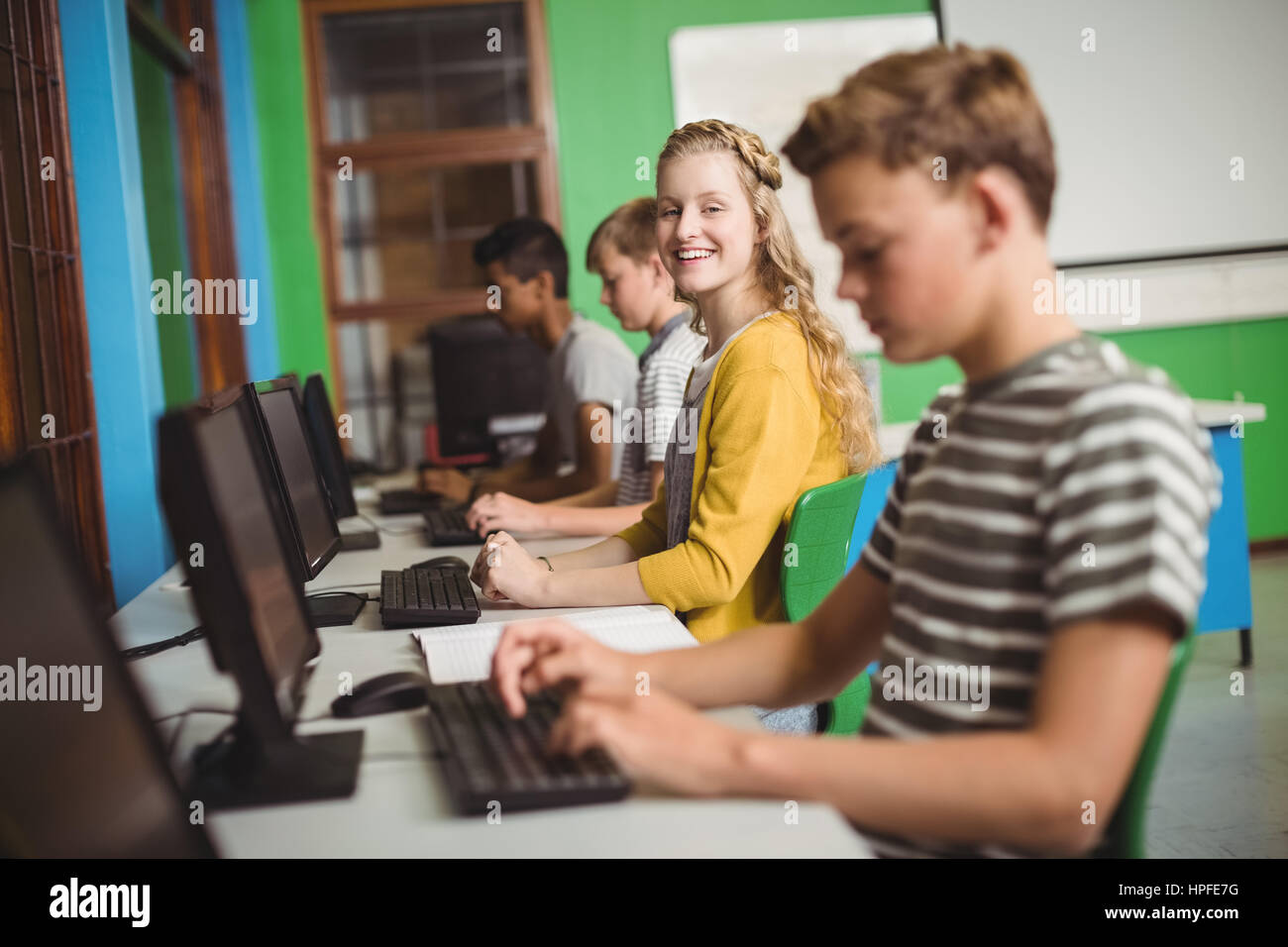 Smiling students studying in computer classroom at school Stock Photo ...