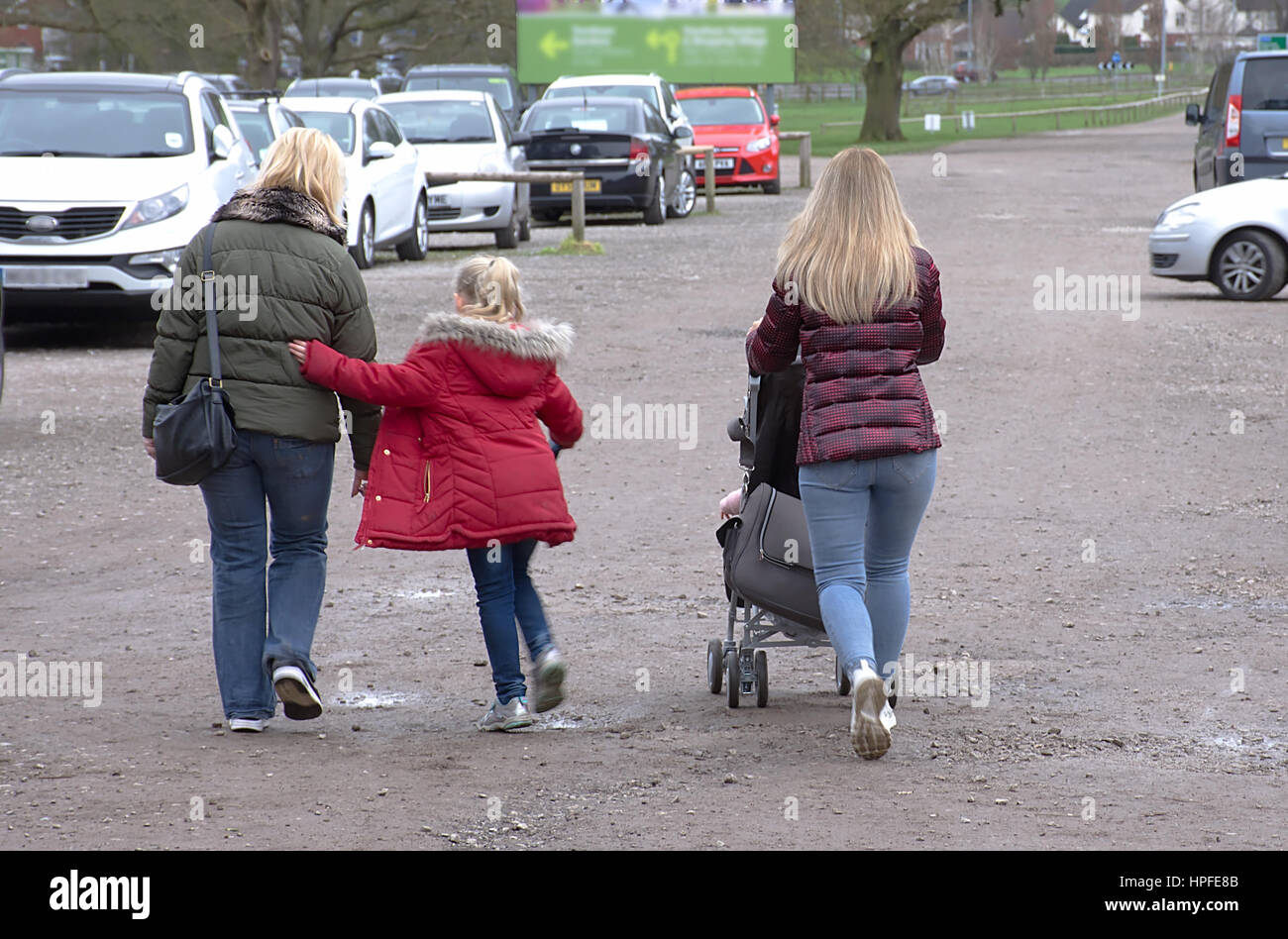 Grand mother with daughter and grandchildren walking towards car on car ...