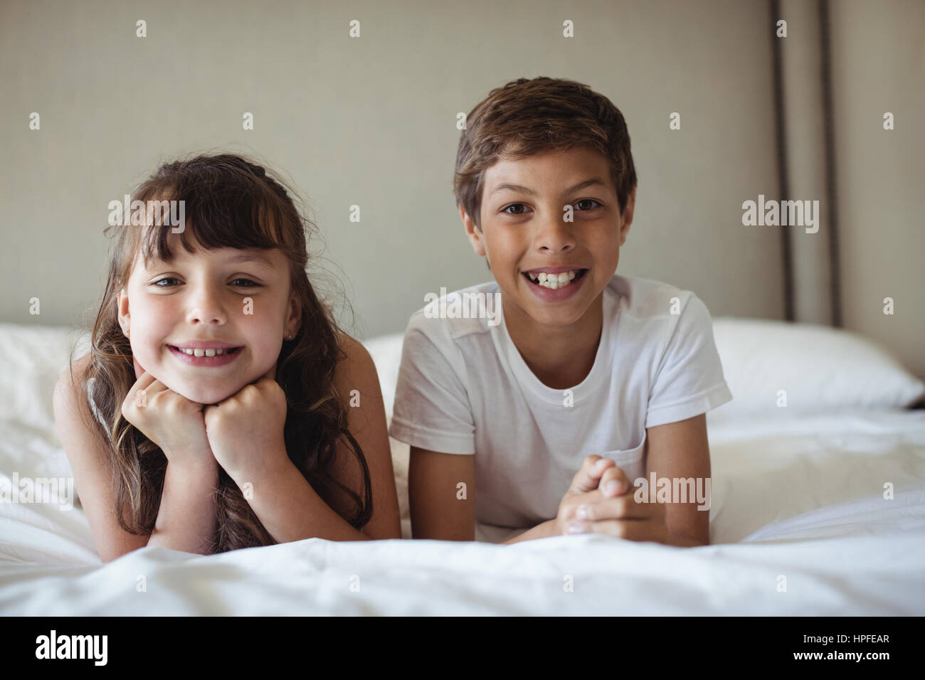 Siblings smiling in bed at home Stock Photo - Alamy