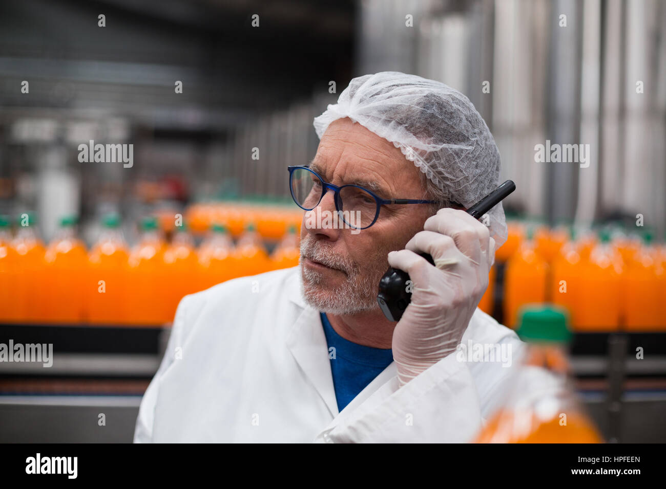 Factory engineer talking on walkie talkie in bottle factory Stock Photo ...