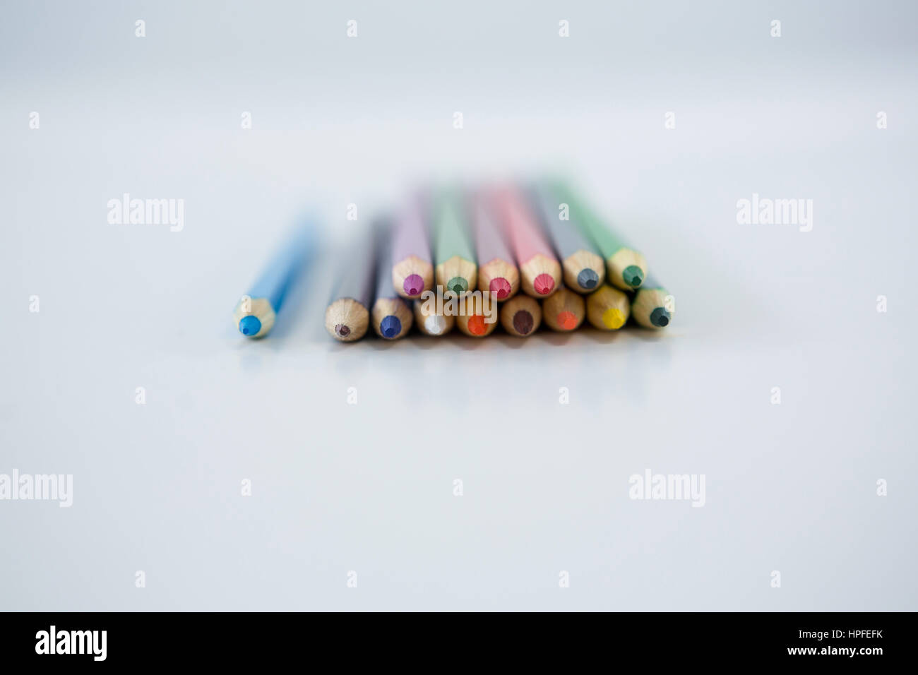 Colored pencils arranged in a row on white background Stock Photo - Alamy