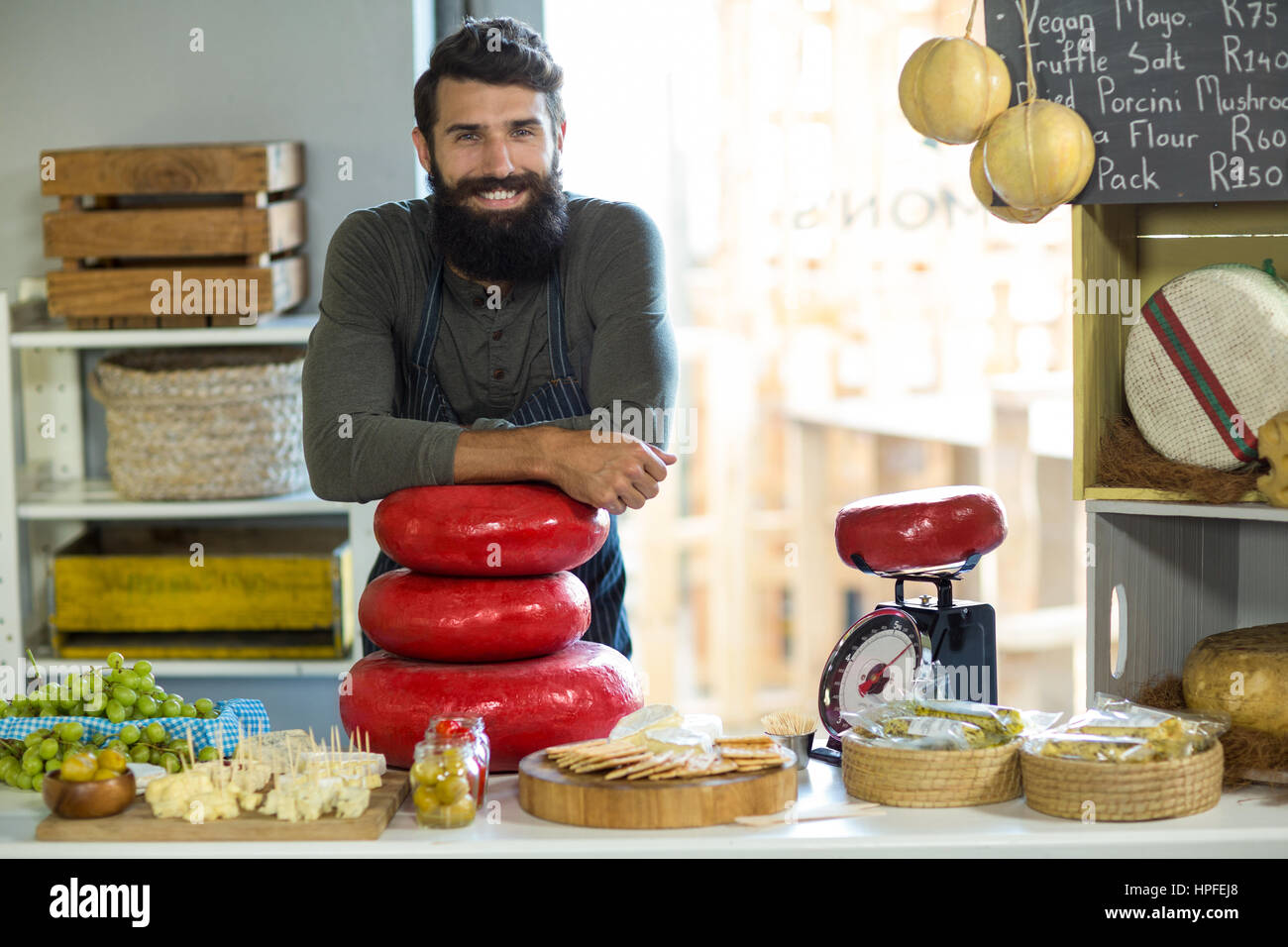 Portrait of happy salesman standing at counter in grocery shop Stock ...