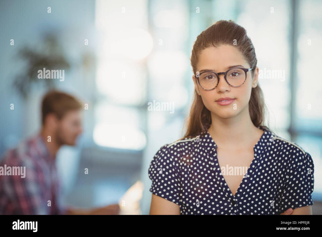 Portrait of female business executive wearing spectacles in office ...