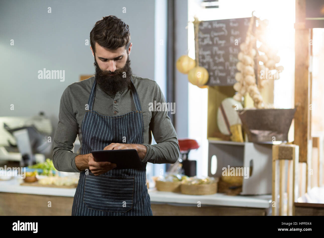 Salesman using digital tablet at counter in grocery shop Stock Photo ...
