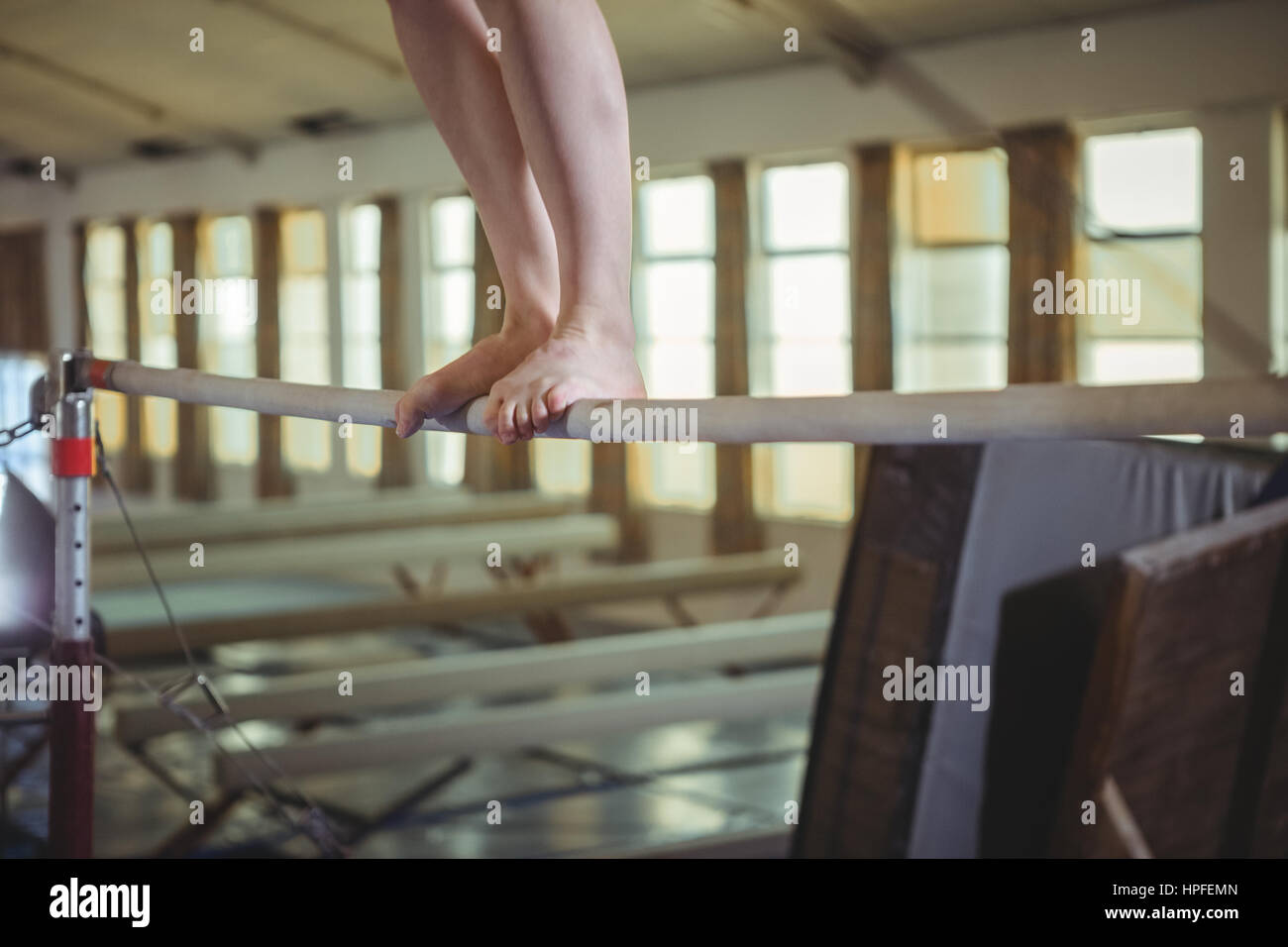 Low-section of a female gymnast practicing gymnastics on the horizontal ...