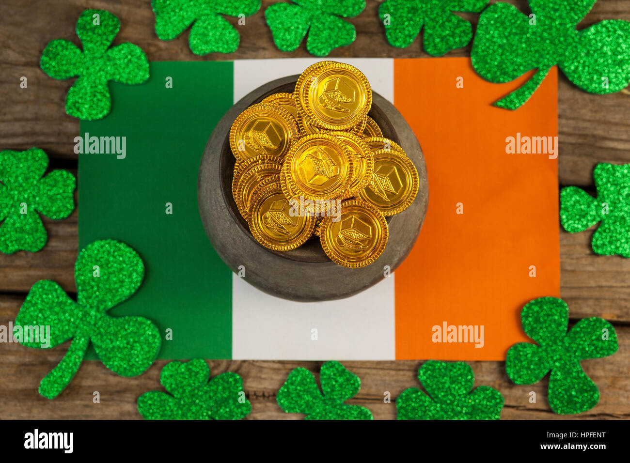 St. Patricks Day pot of chocolate gold coins and irish flag surrounded ...