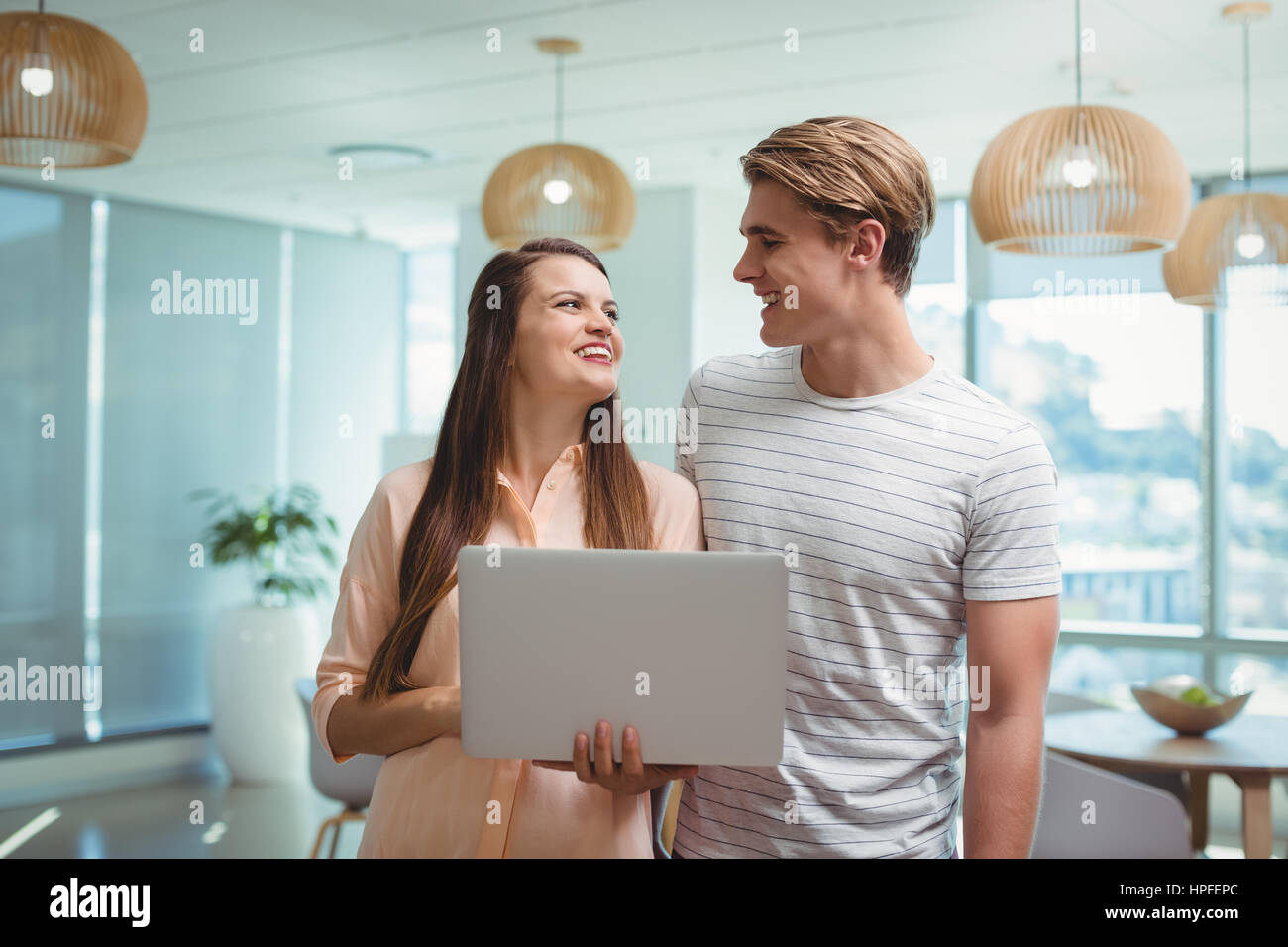 Happy executives using laptop in office Stock Photo - Alamy