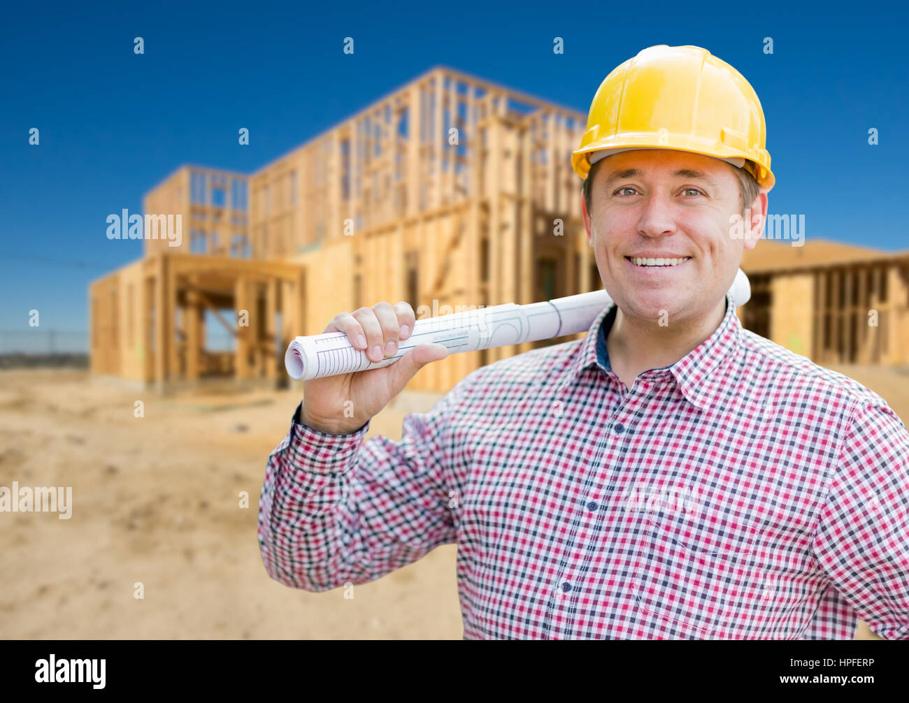 Smiling Contractor Wearing Hardhat Holding Blueprints at Home ...