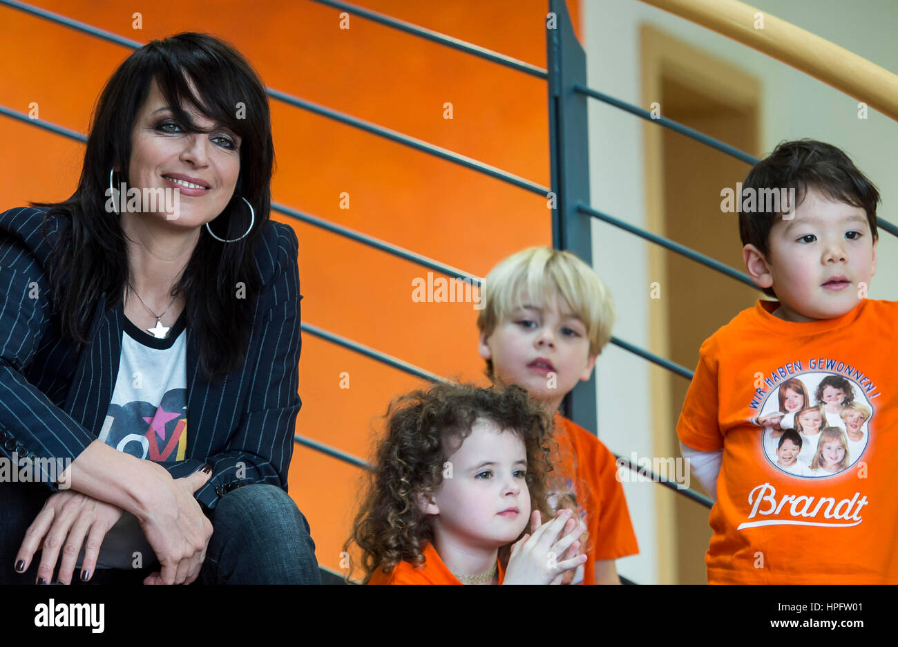Pop singer Nena posing with children during her visit to the company ...