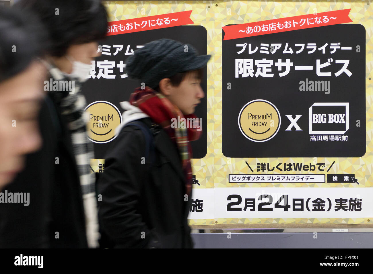Pedestrians walk past a Premium Friday advertisement on display at ...