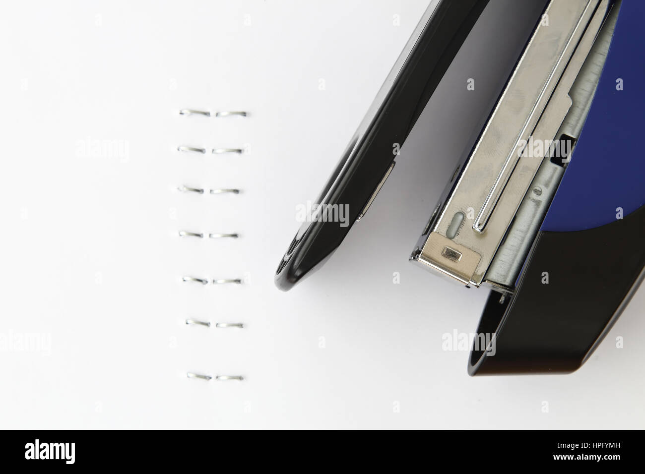 Blue stapler and staples with paper on white table Stock Photo - Alamy