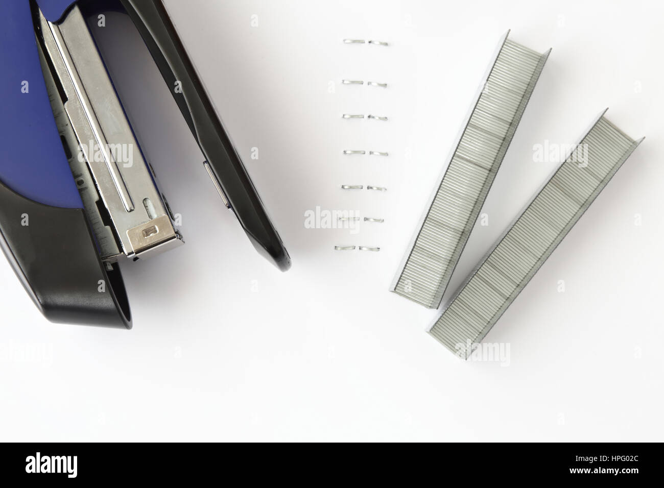 Blue stapler with staples and paper on white table Stock Photo - Alamy