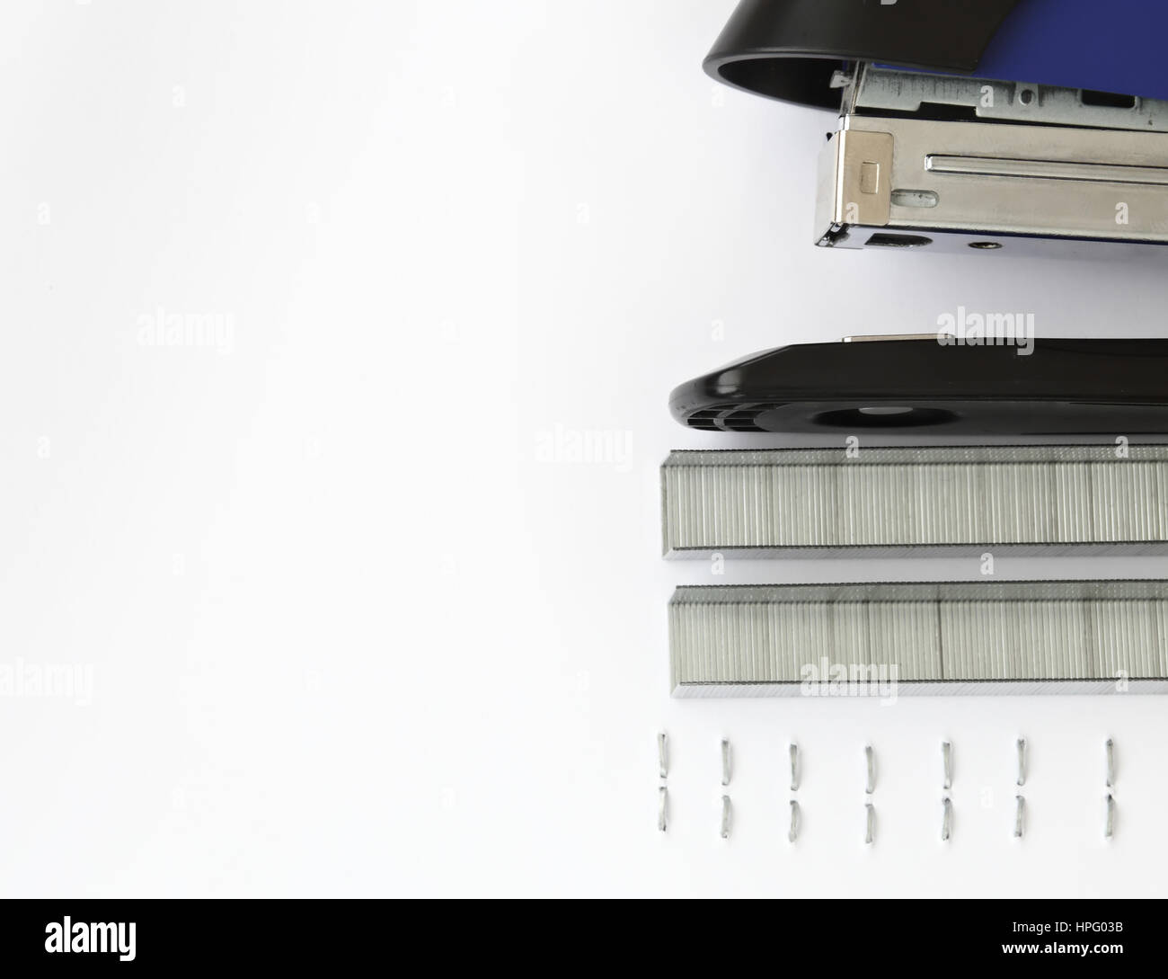 Blue stapler and staples with paper on wood table Stock Photo - Alamy