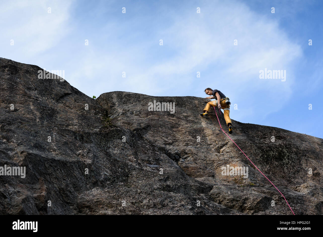 Outdoor sport. Rock climber ascending a challenging cliff. Extreme ...