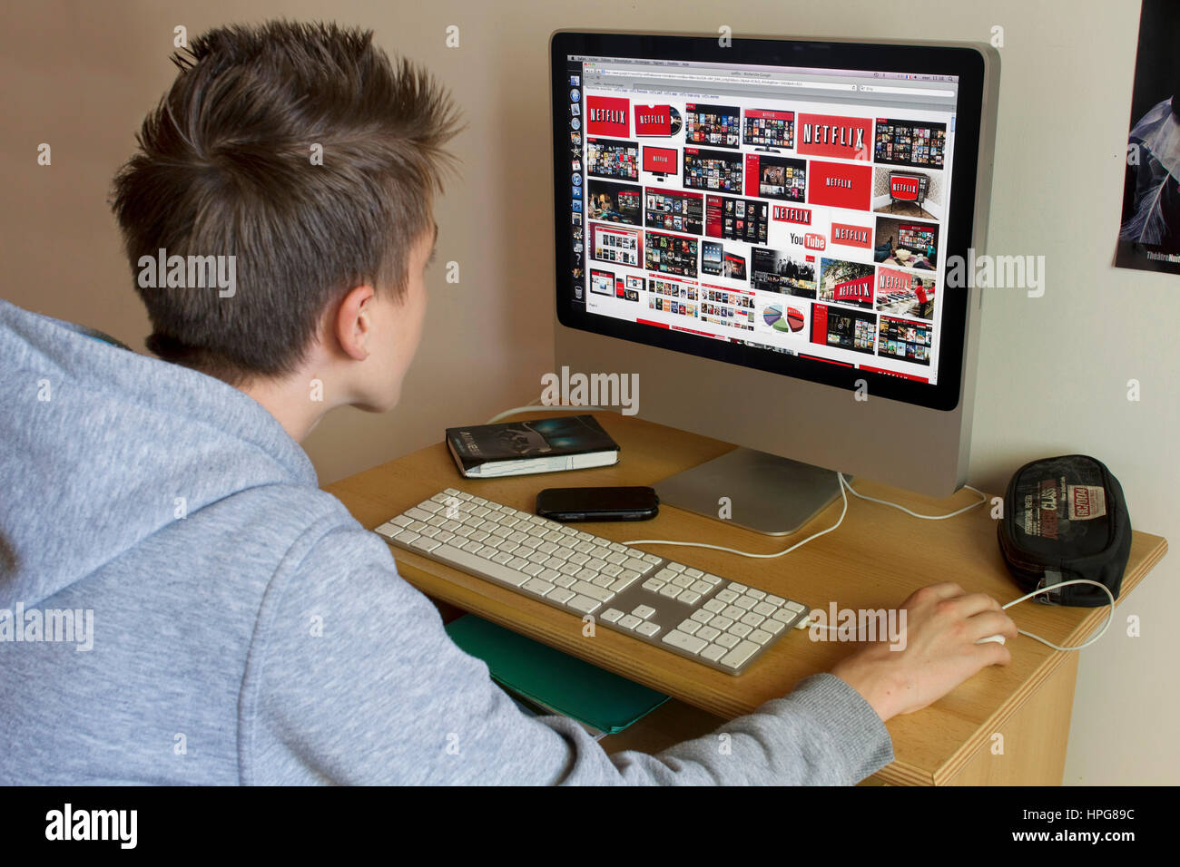 Schoolboy in front of a computer screen displaying Netflix Stock Photo ...