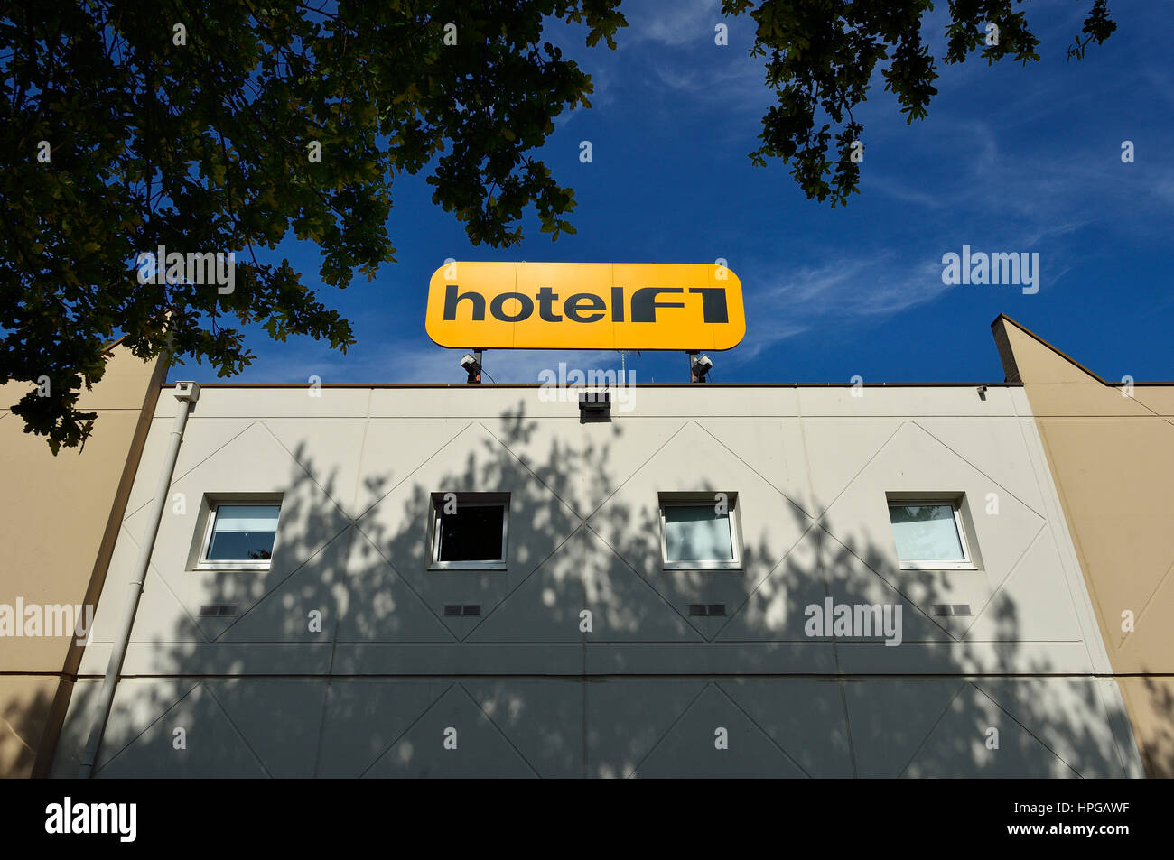 France, Formule 1 Hotel facade and its sign against a blue sky. Foliage ...