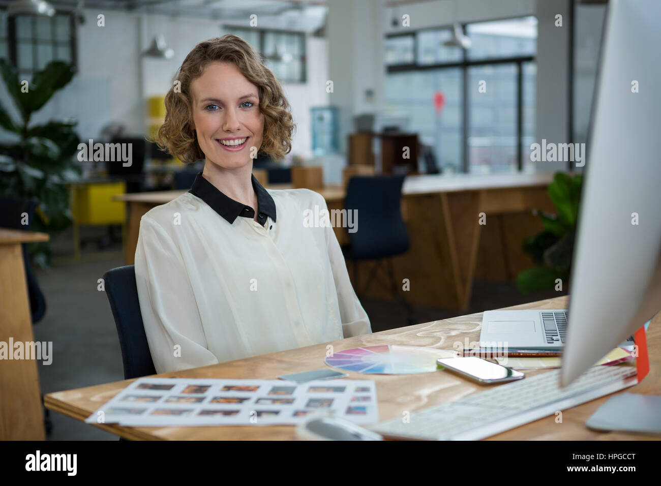 Female graphic designer working at desk in creative office Stock Photo ...