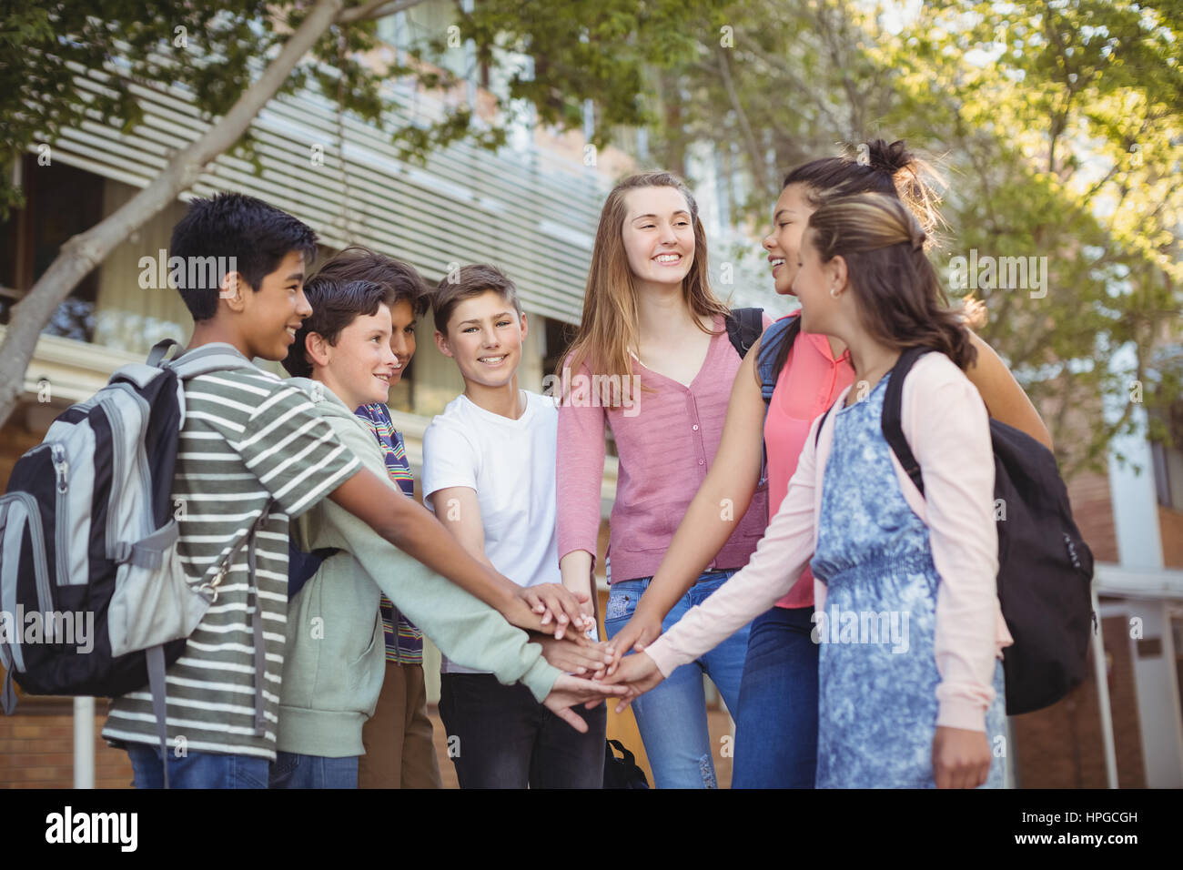 Happy school kids forming hand stack in campus at school Stock Photo ...