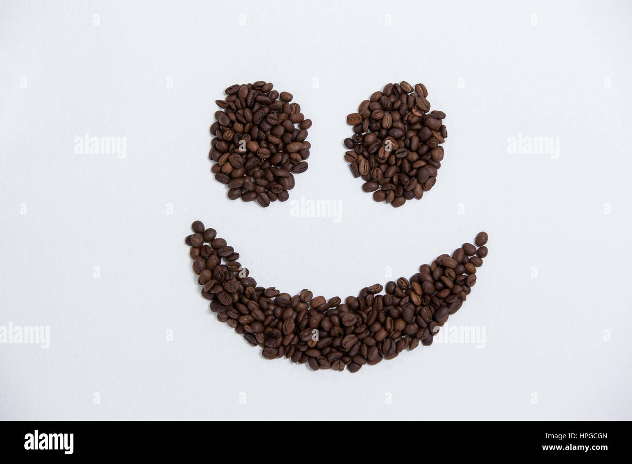 Coffee beans forming smiley on white background Stock Photo - Alamy