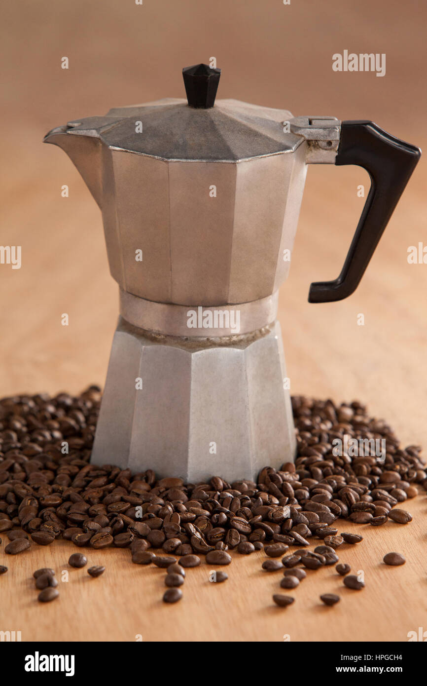 Metallic coffee maker with coffee beans on wooden background Stock ...