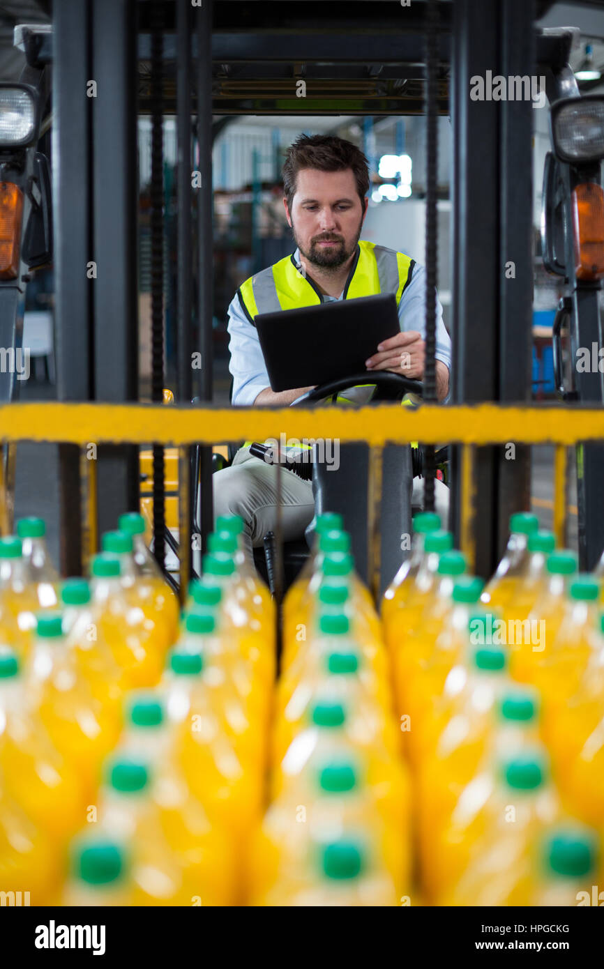 Attentive factory worker using digital tablet in forklift Stock Photo ...