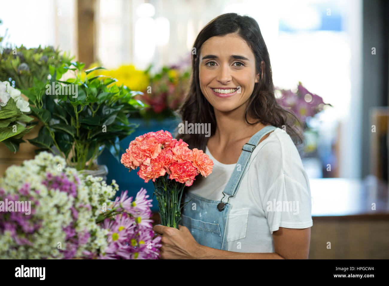 Portrait of a smiling woman selecting flowers at florist shop Stock ...