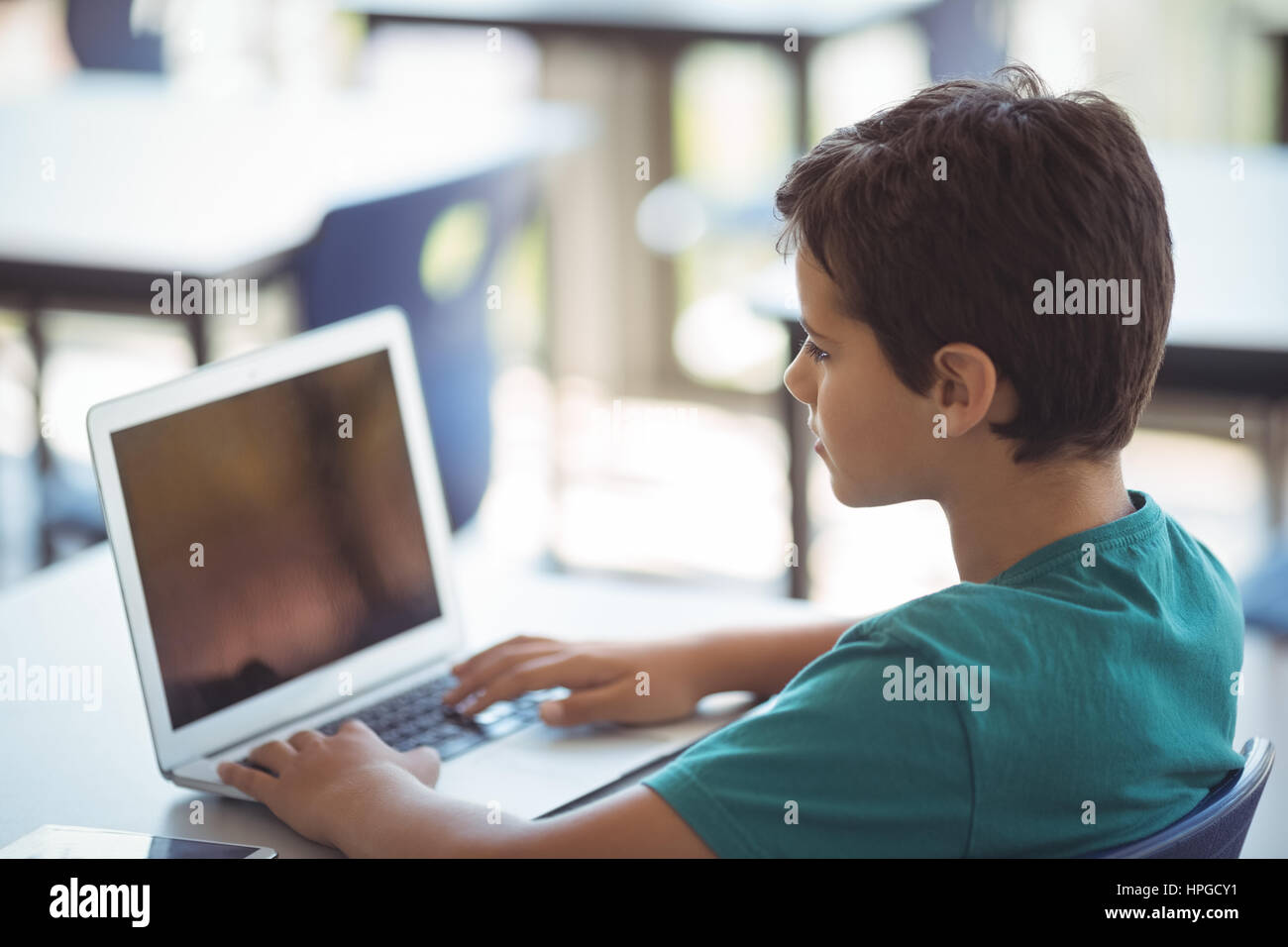 Schoolboy using laptop in classroom at school Stock Photo - Alamy