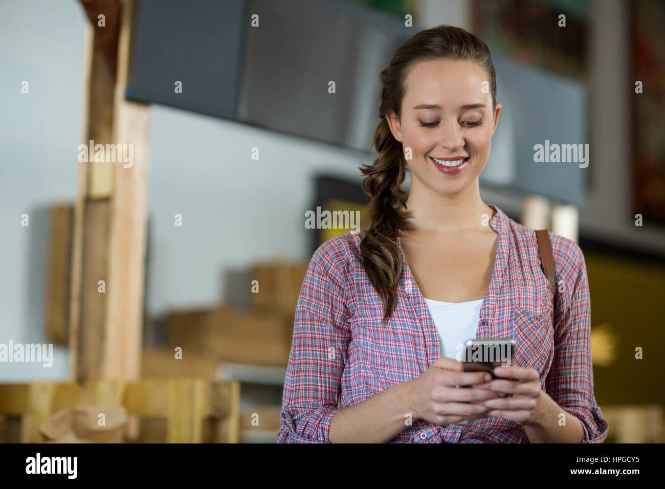 Smiling female customer using mobile phone in grocery store Stock Photo ...
