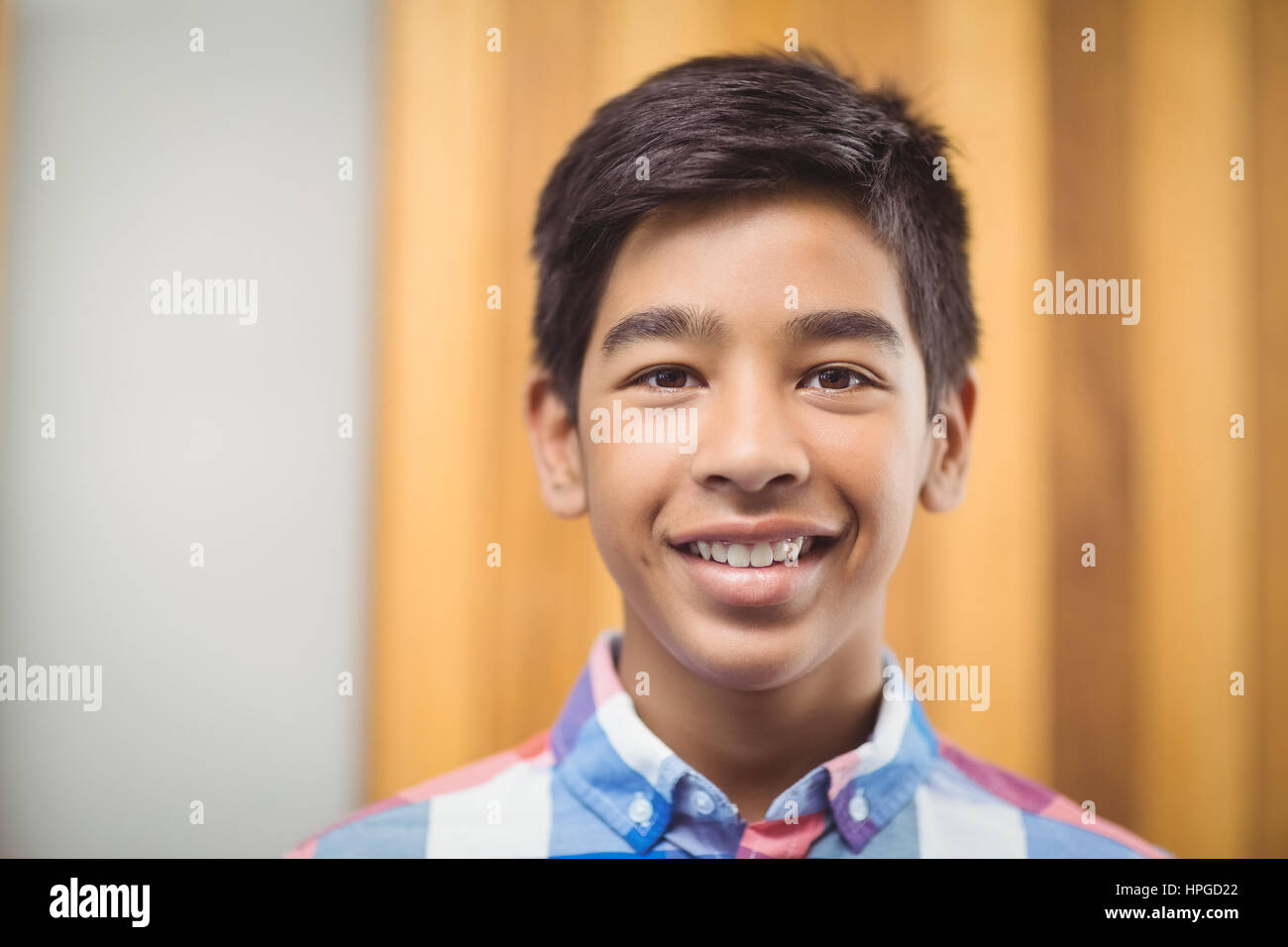 Portrait of smiling schoolboy in school Stock Photo - Alamy