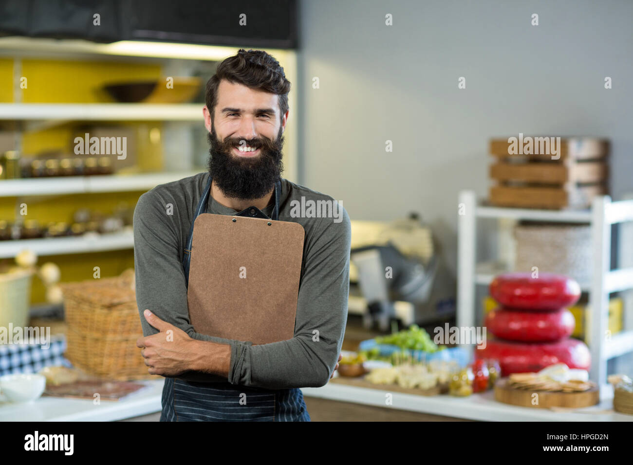 Portrait of salesman holding clipboard at counter in grocery shop Stock ...