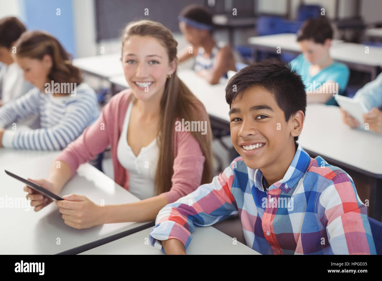 Portrait of students with digital tablet in classroom at school Stock ...