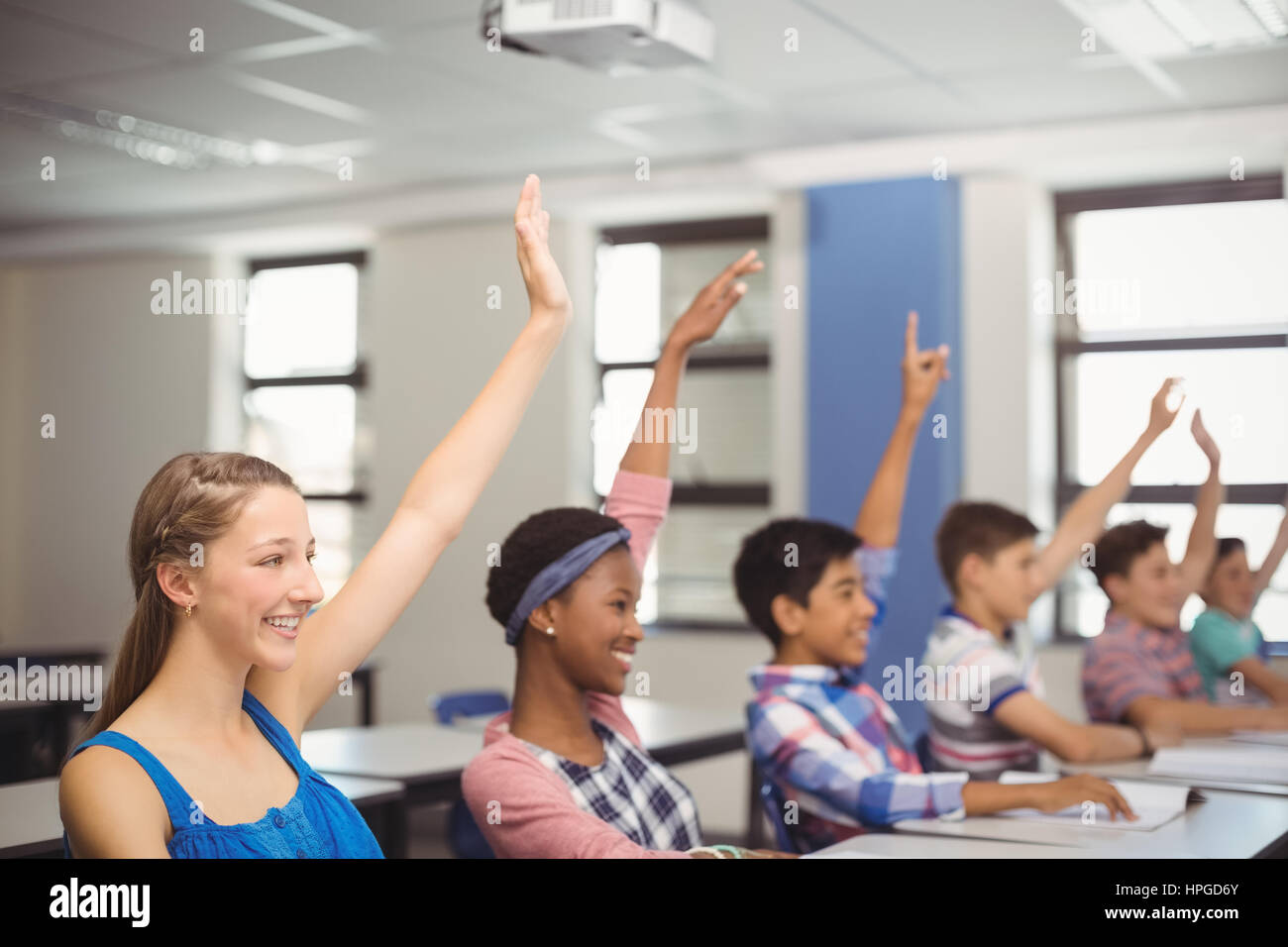 Student raising hand in classroom at school Stock Photo - Alamy