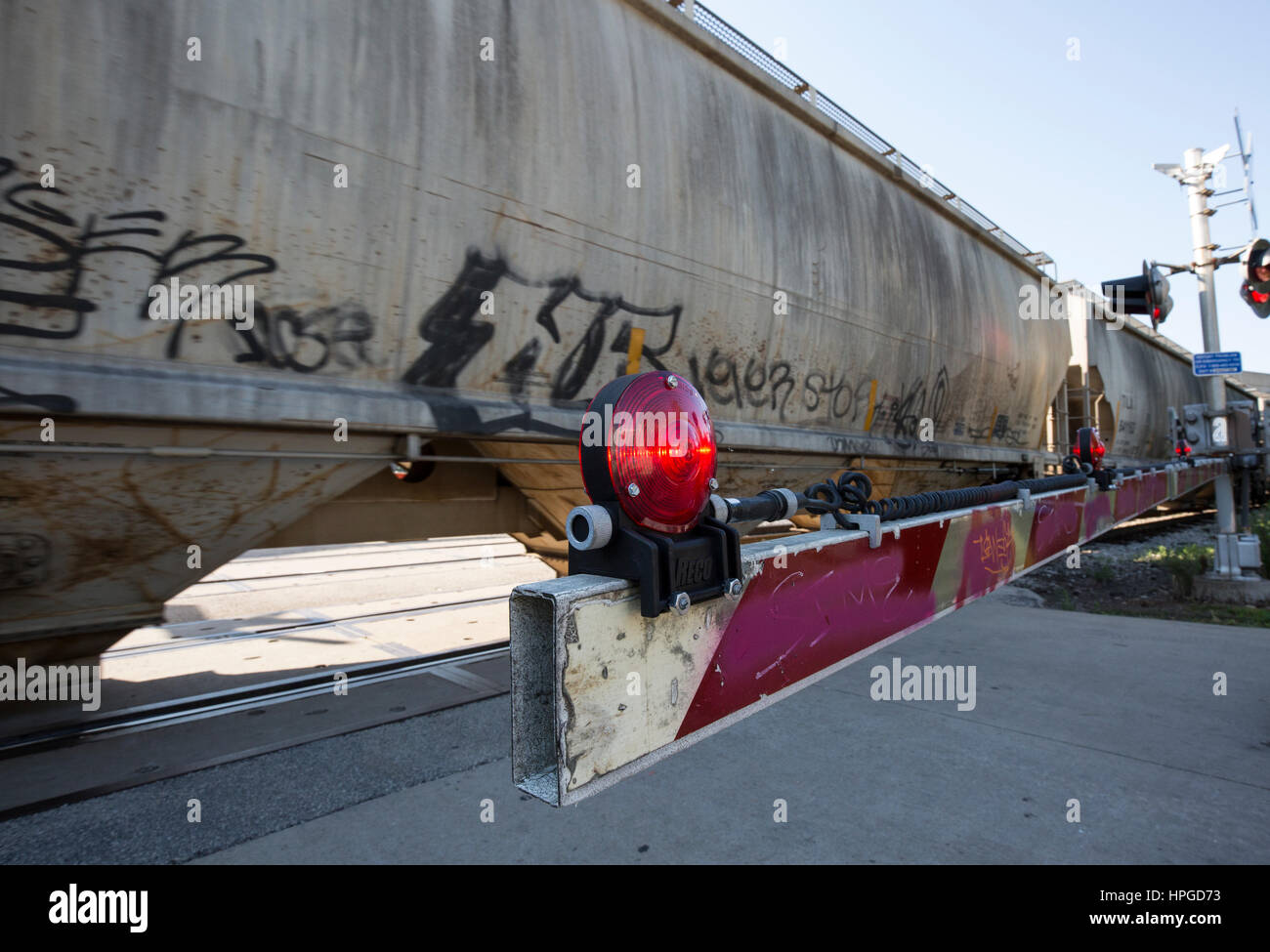 Down railroad gate at crossing, with train in background Stock Photo ...