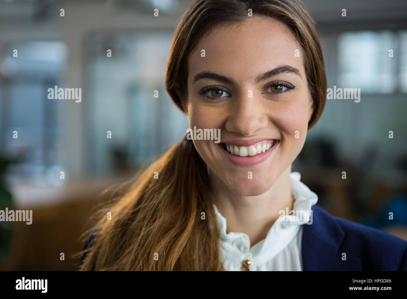 Portrait of smiling female executive standing in creative office Stock ...