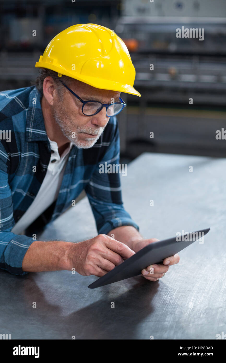 Attentive factory worker using a digital tablet in factory Stock Photo ...