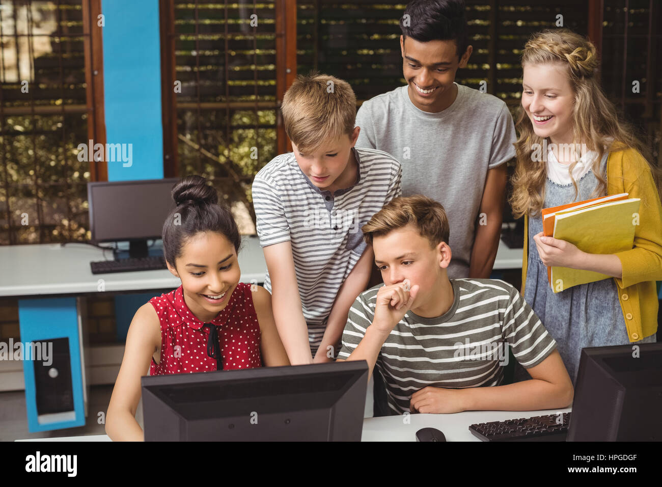 Smiling students studying in computer classroom at school Stock Photo ...