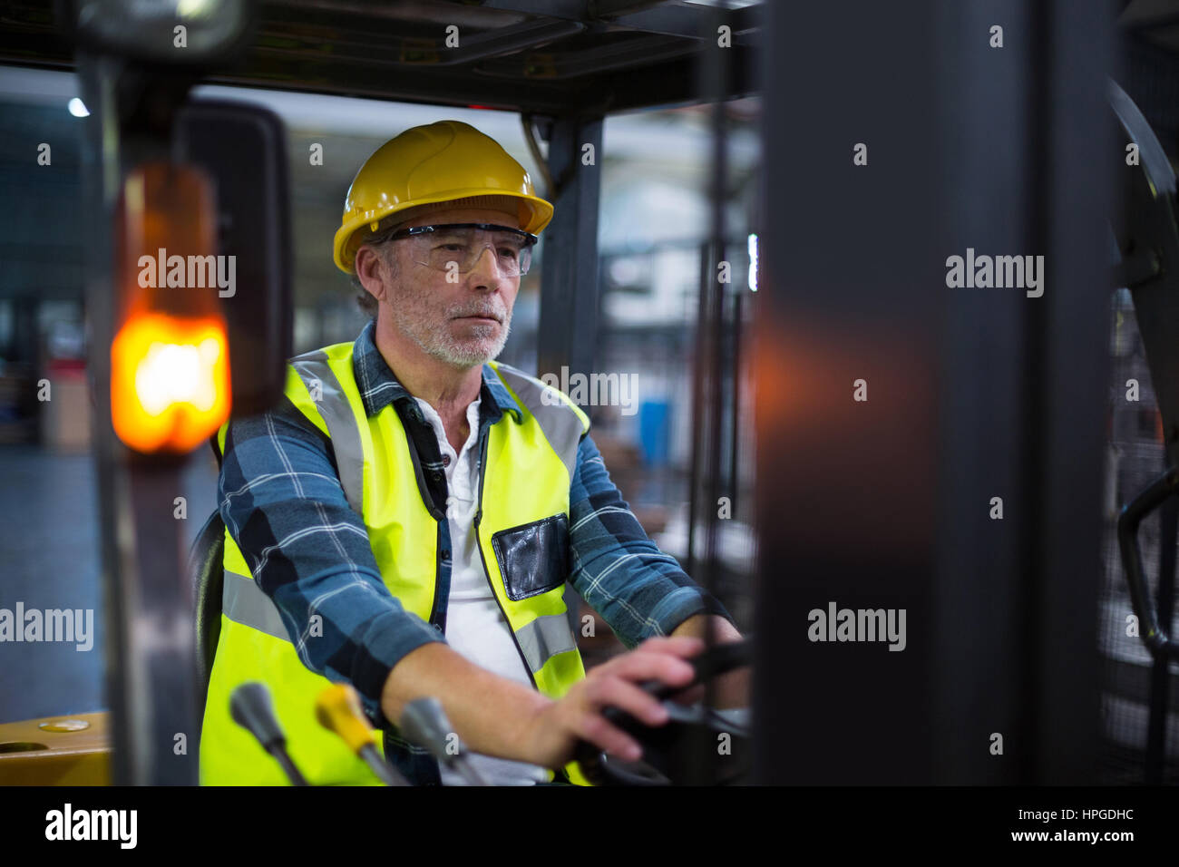 Factory worker driving forklift in drinks production factory Stock ...