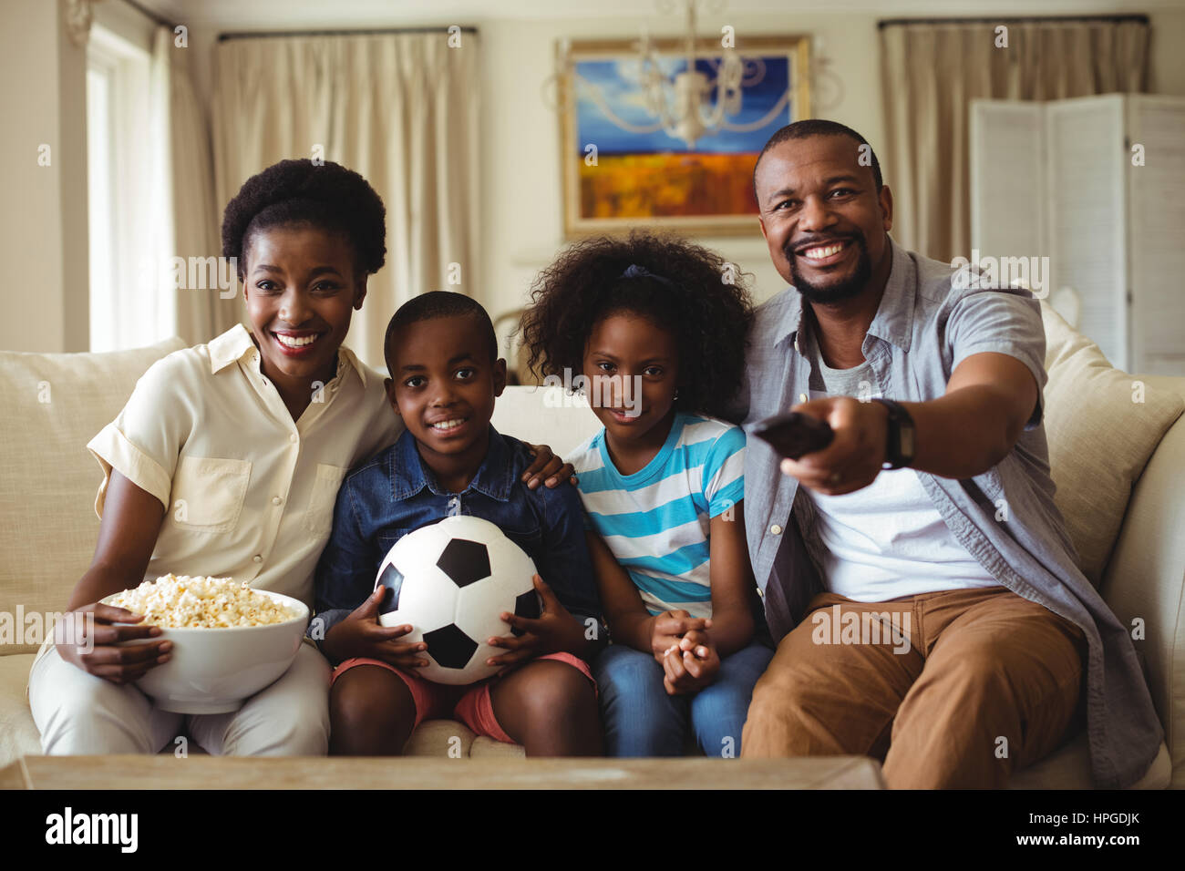 Parents and kids watching television in living room at home Stock Photo ...