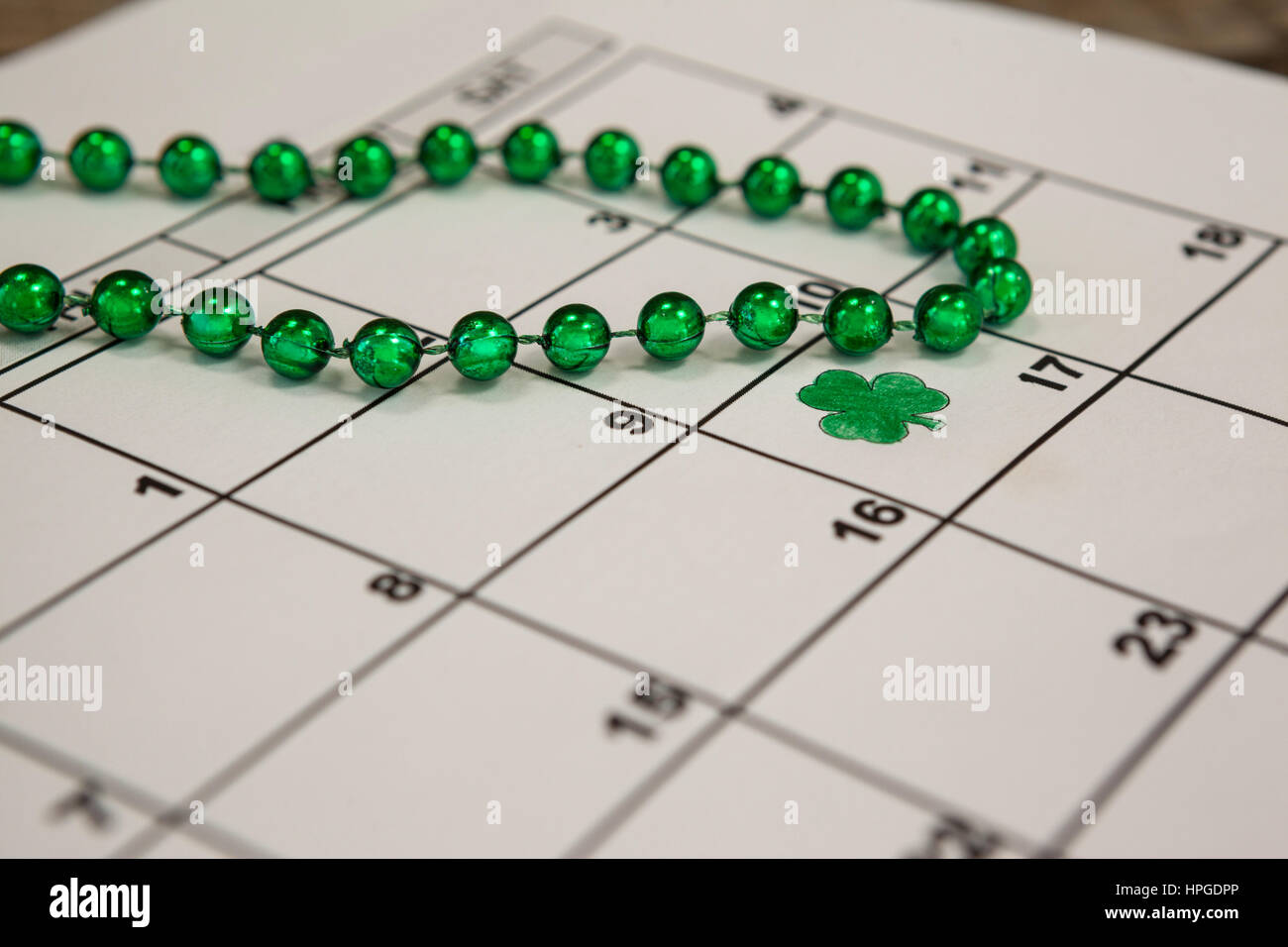 St. Patricks Day close-up of shamrock and beads kept on calendar Stock ...