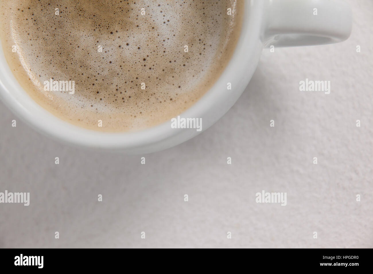 Close-up of white coffee cup with creamy froth on white background ...