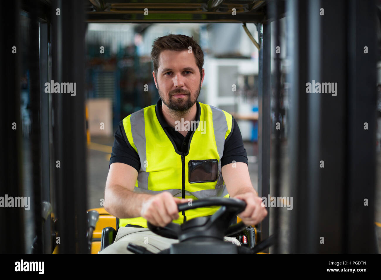 Portrait of factory worker driving forklift in factory Stock Photo - Alamy