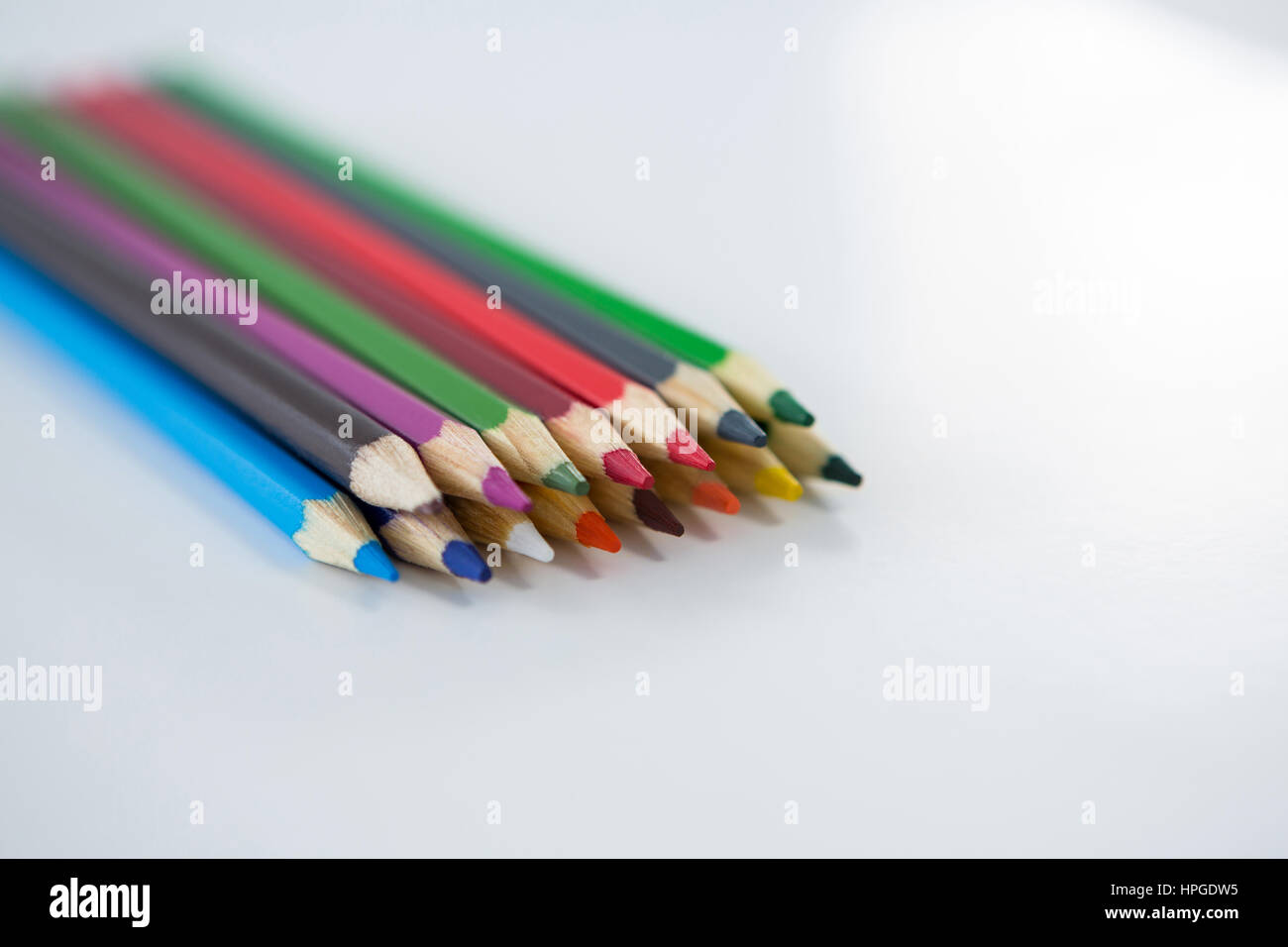 Colored pencils arranged in a row on white background Stock Photo - Alamy