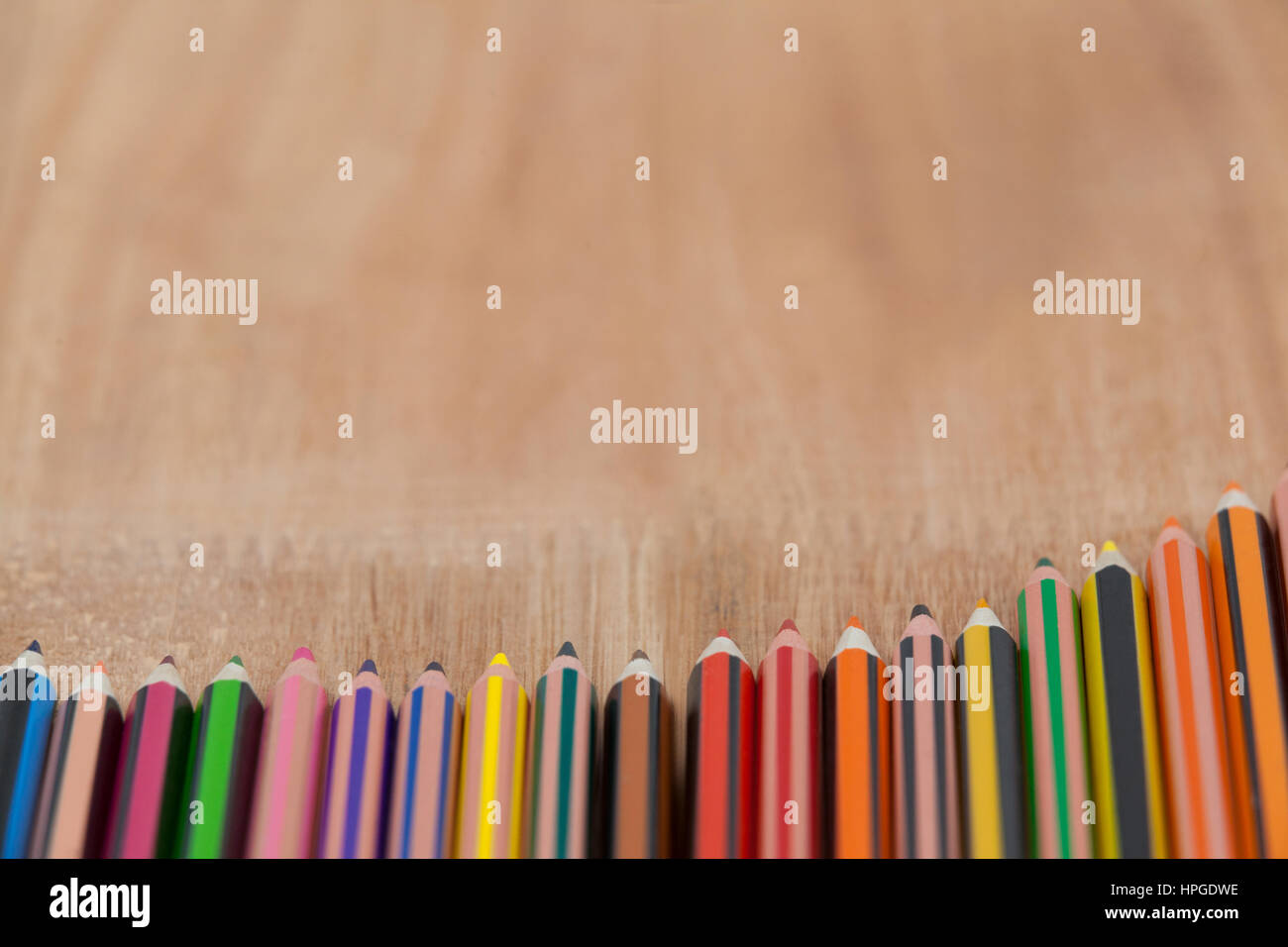 Colorful color pencil arranged in diagonal line on wooden background ...