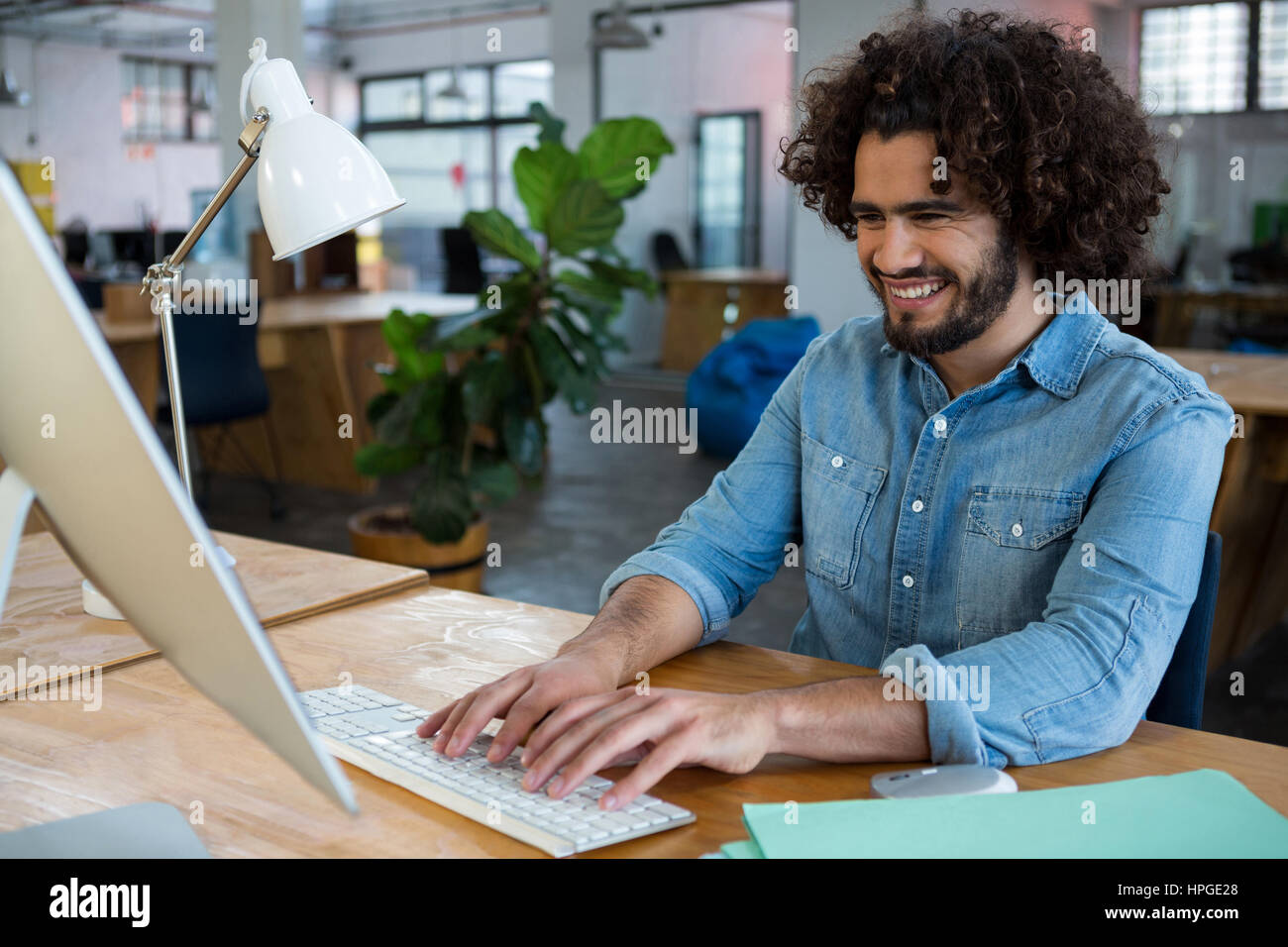 Happy male graphic designer working at desk in creative office Stock ...
