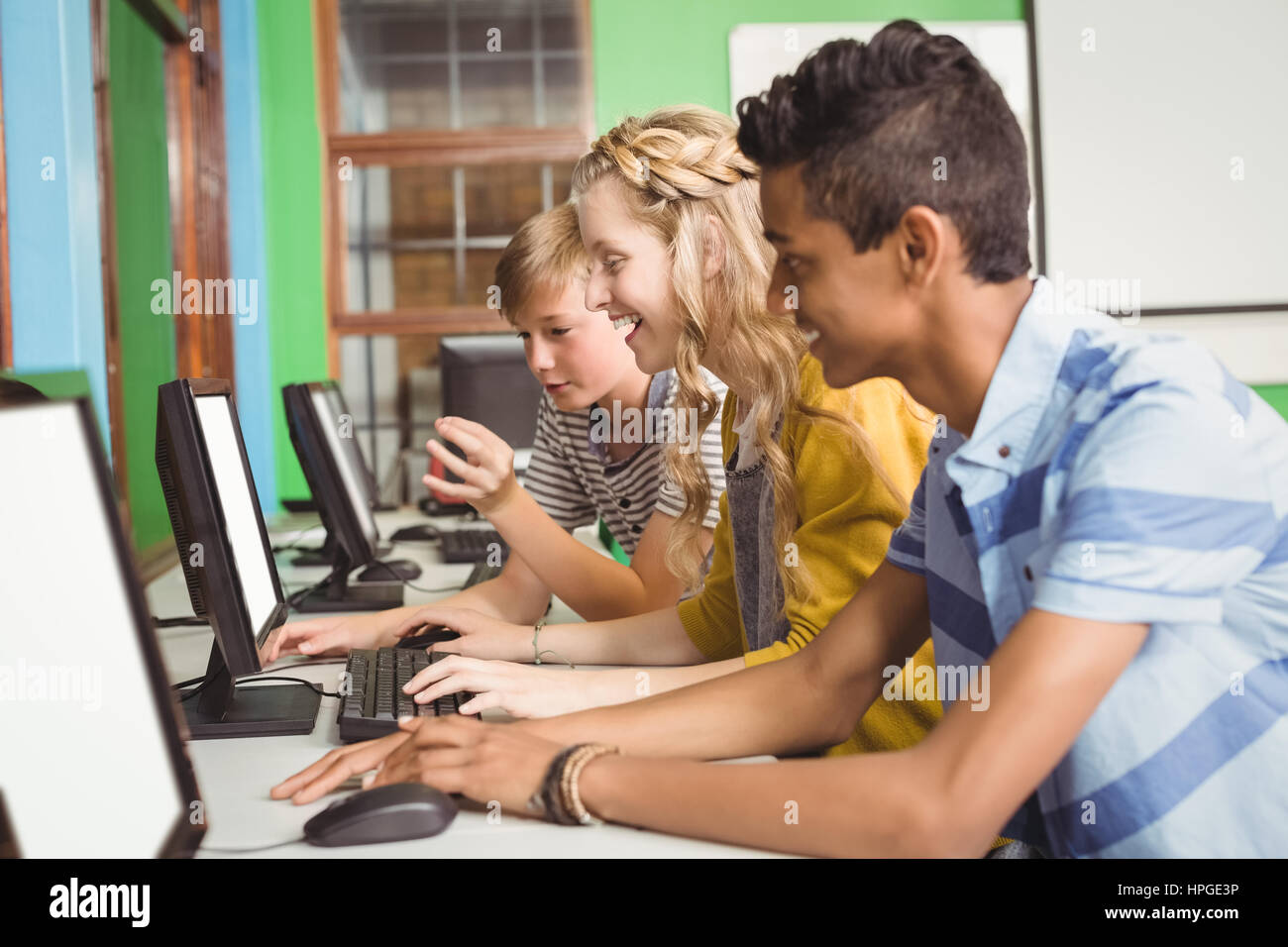 Smiling students studying in computer classroom at school Stock Photo ...