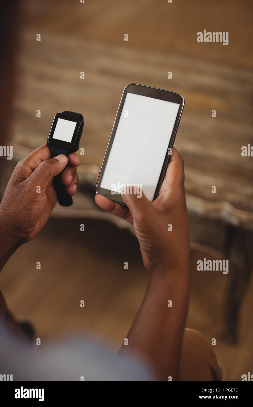 Man using smartwatch and smartphone at home Stock Photo - Alamy