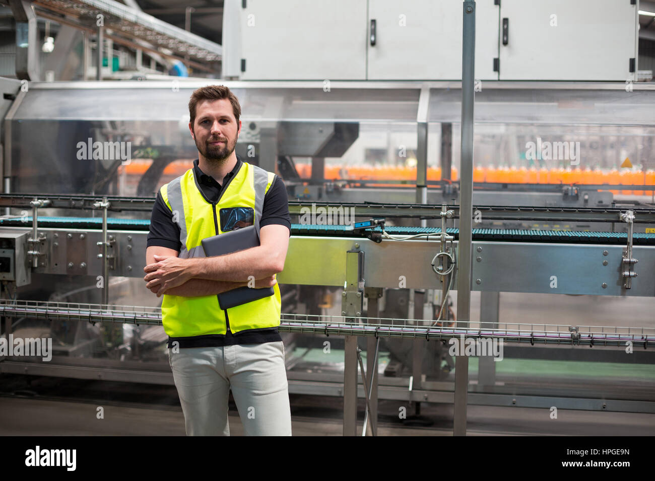Portrait of confident factory worker standing with a digital tablet in ...