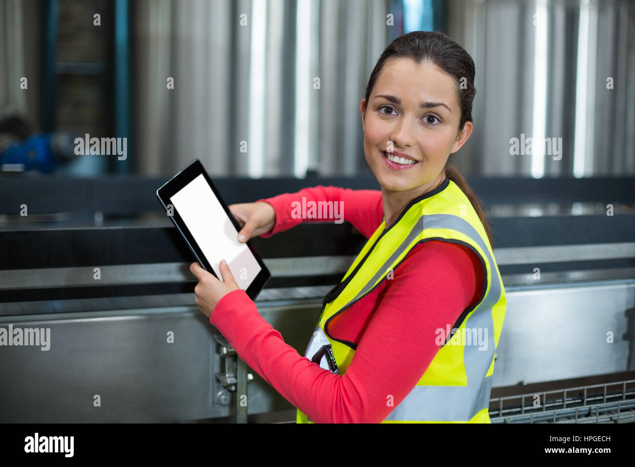 Portrait of female factory worker using digital tablet at drinks ...