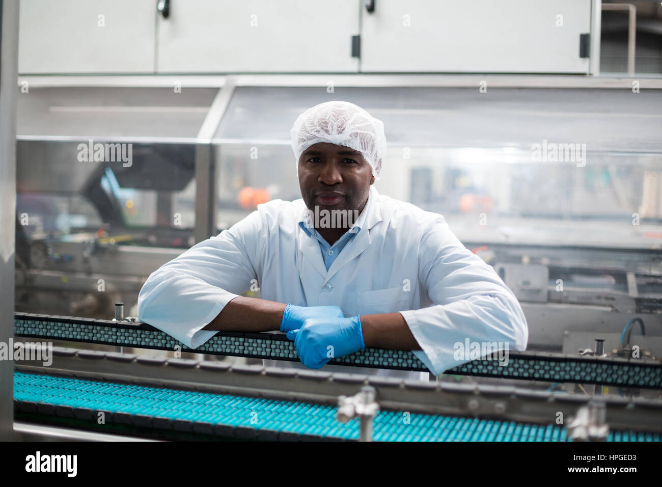 Portrait of factory engineer leaning on production line in drinks ...